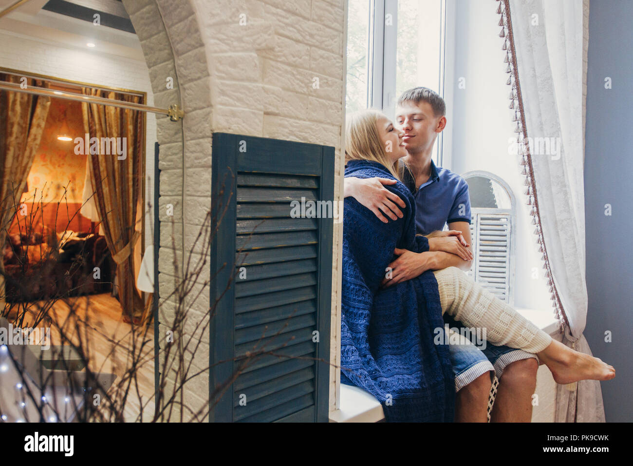 Couple in love sitting at home on the window. Tender loving embrace of ...