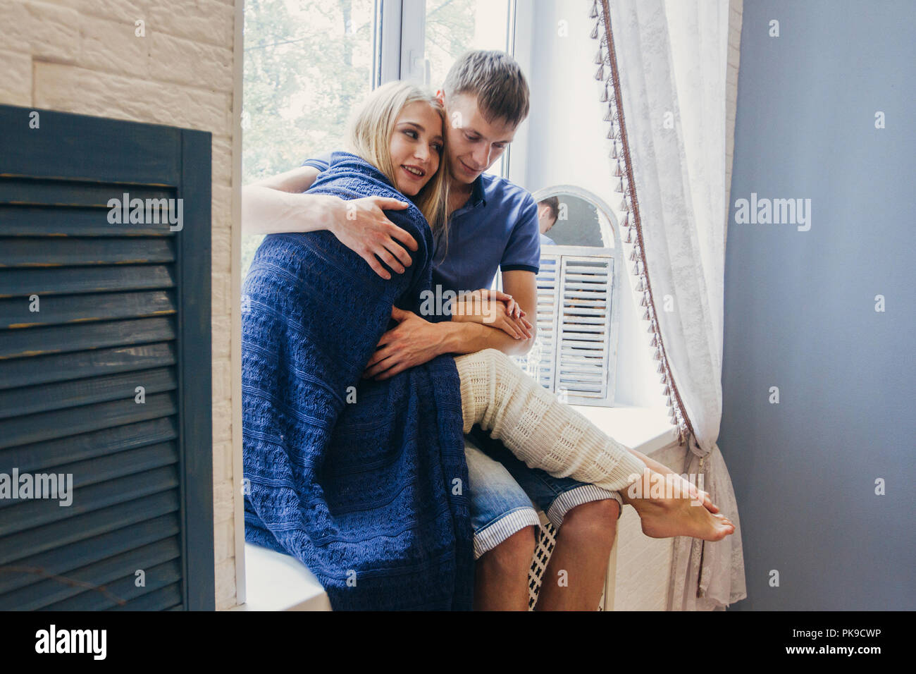Couple in love sitting at home on the window. Tender loving embrace of ...
