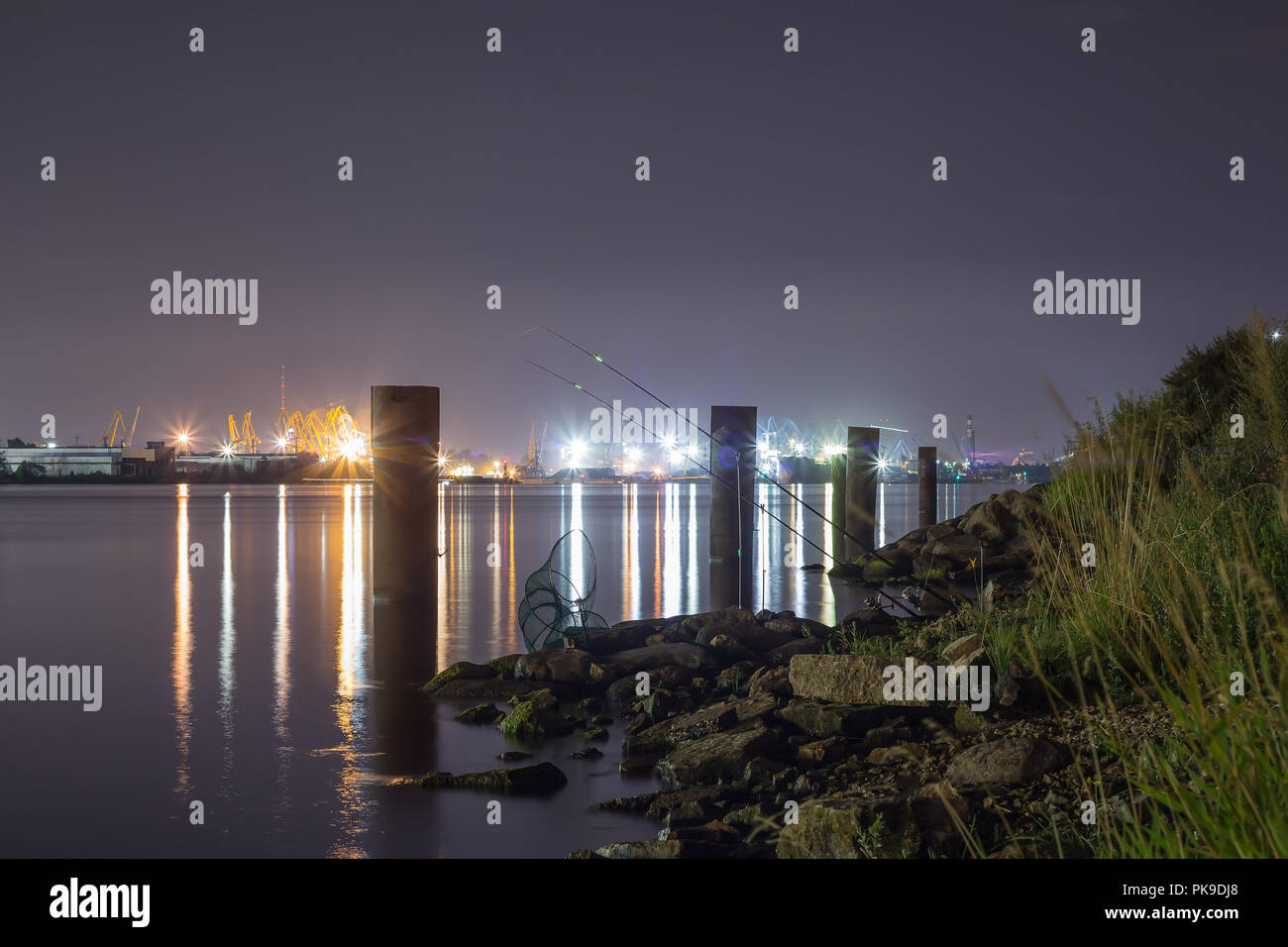 Fishing in the summer night next to container terminal in Riga port ...