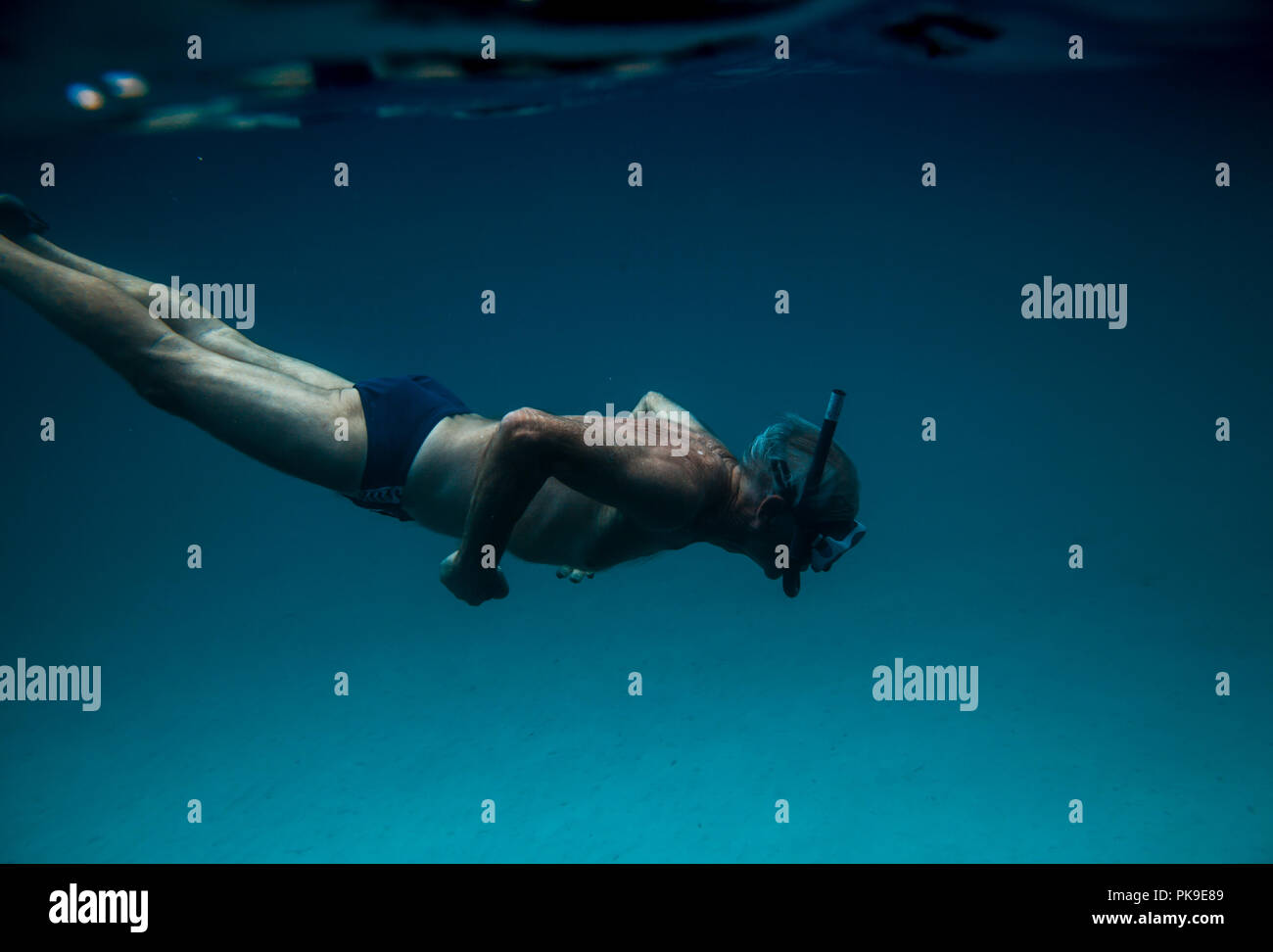 senior man floating underwater on the blue ocean -health and activity ...