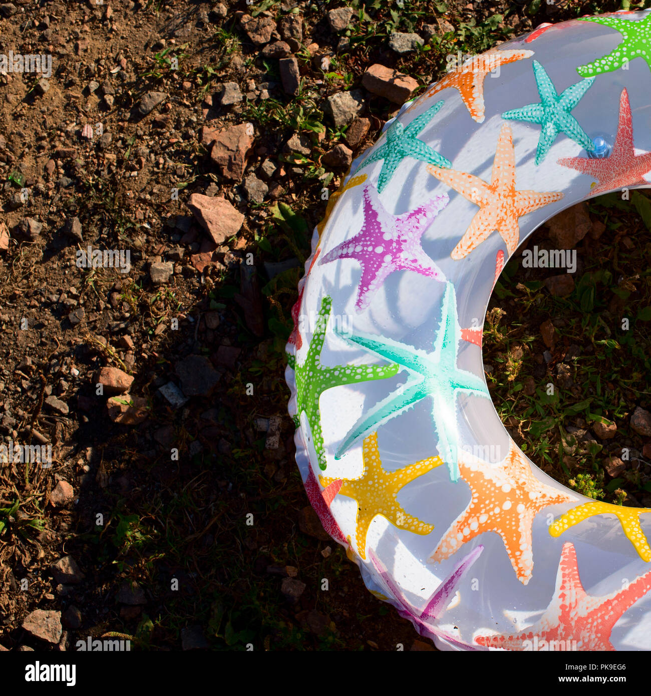 Bright children's inflatable circle lying on the ground on the beach ...