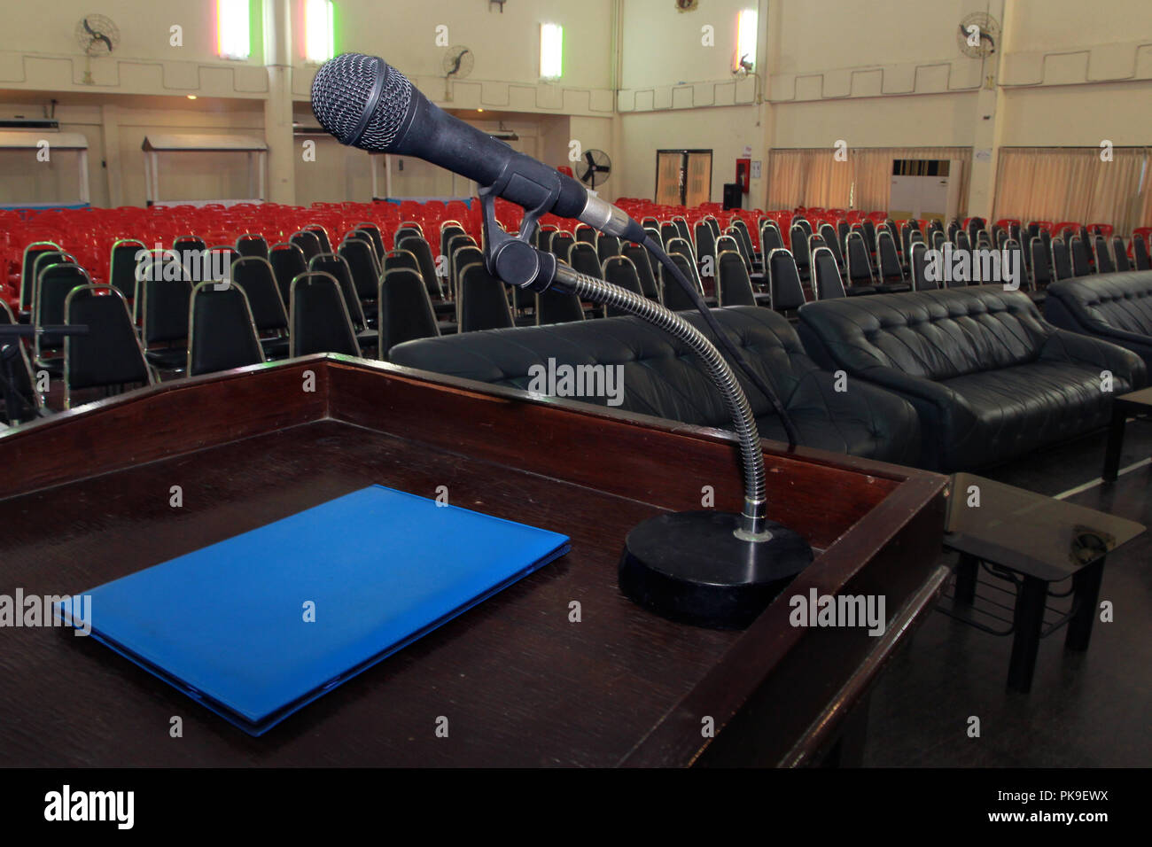 The microphone is located on podium stand at the center of the room is ...