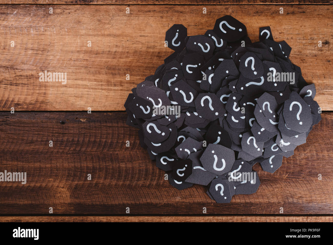 Heap of black paper with QUESTION MARK on wooden table. Concept of ...