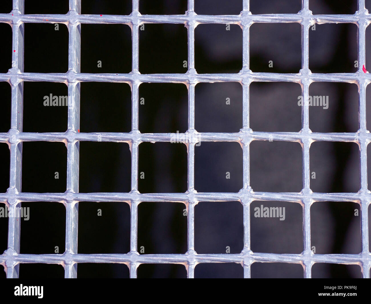 Silver metallic grating of squares on a black background of the waters ...