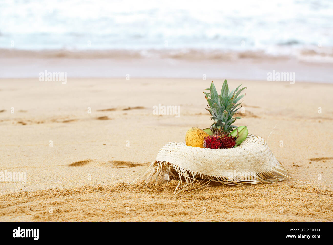 Exotic fruits in a straw hat near the ocean Stock Photo - Alamy