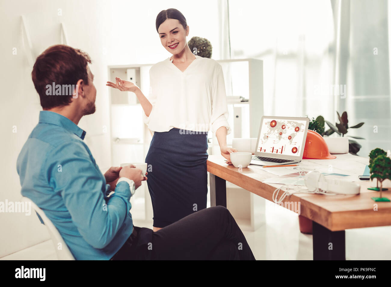 Positive delighted female person talking with her colleague Stock Photo ...