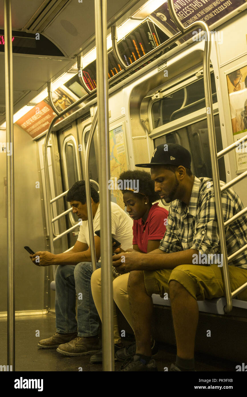 People constantly use their phones while they ride the New York CIty ...