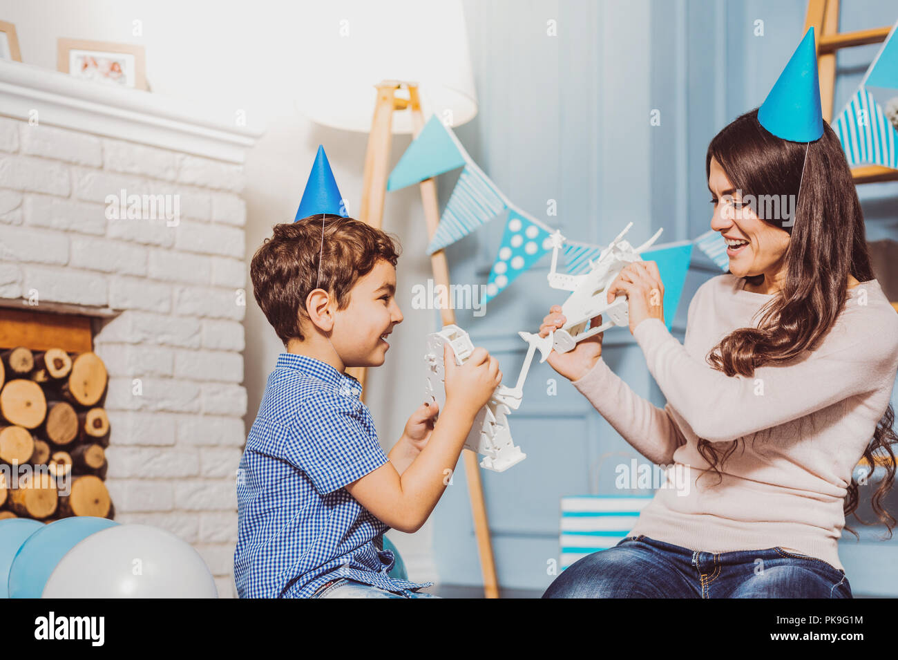 Happy merry woman and boy playing with gifts Stock Photo - Alamy