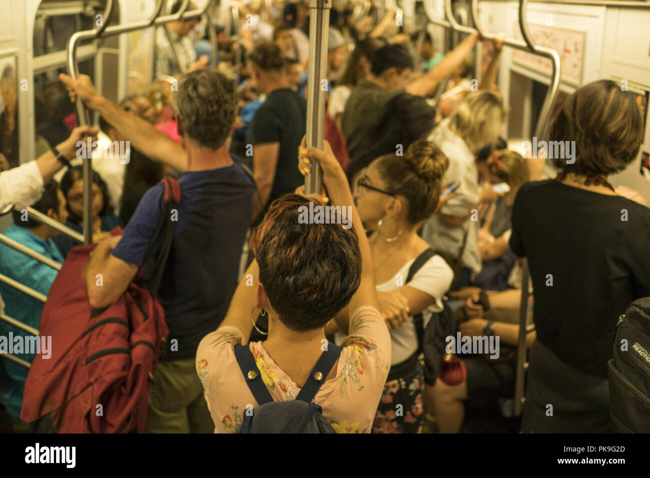 People standing and sitting on a crowded New York City subway train ...