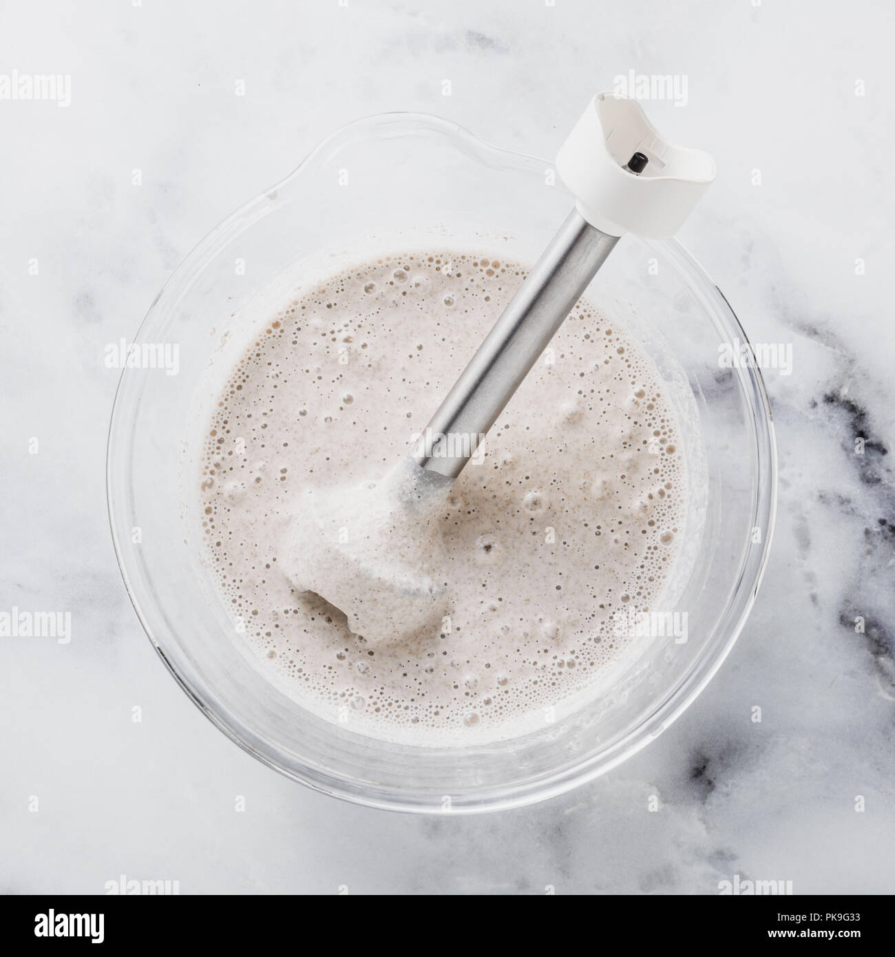 prepare batter for pancakes in a glass bowl with a hand blender on a ...