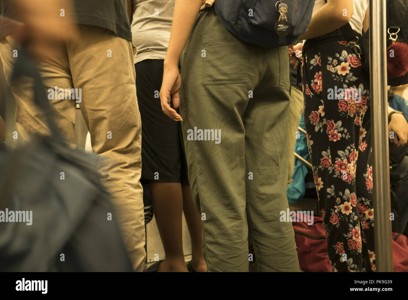 People standing and sitting on a crowded New York City subway train ...