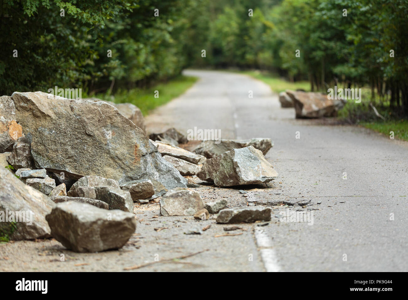 Asphalt road broken by a mountain avalanche Stock Photo - Alamy