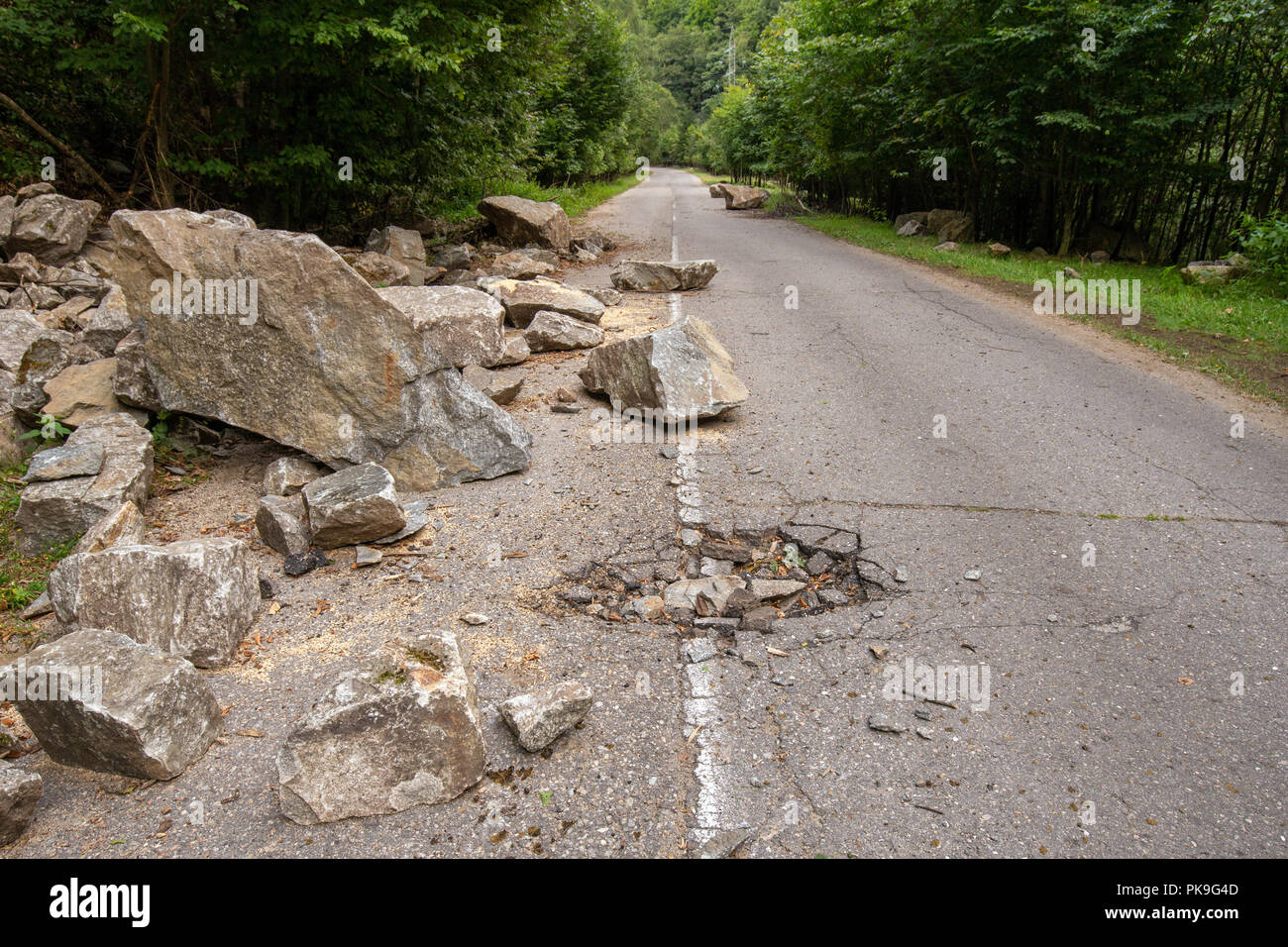 Asphalt road broken by a mountain avalanche Stock Photo - Alamy