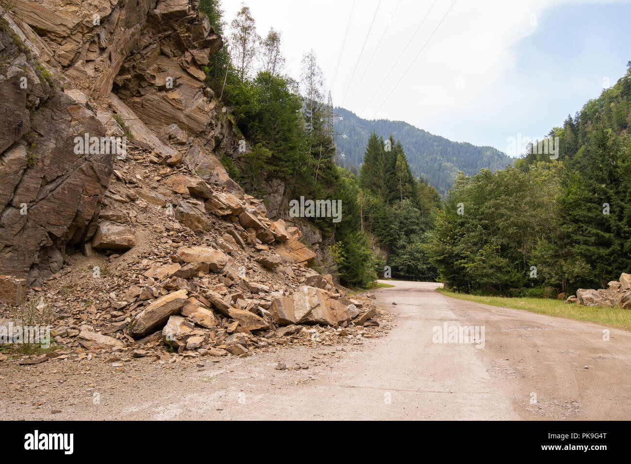 Asphalt road broken by a mountain avalanche Stock Photo - Alamy