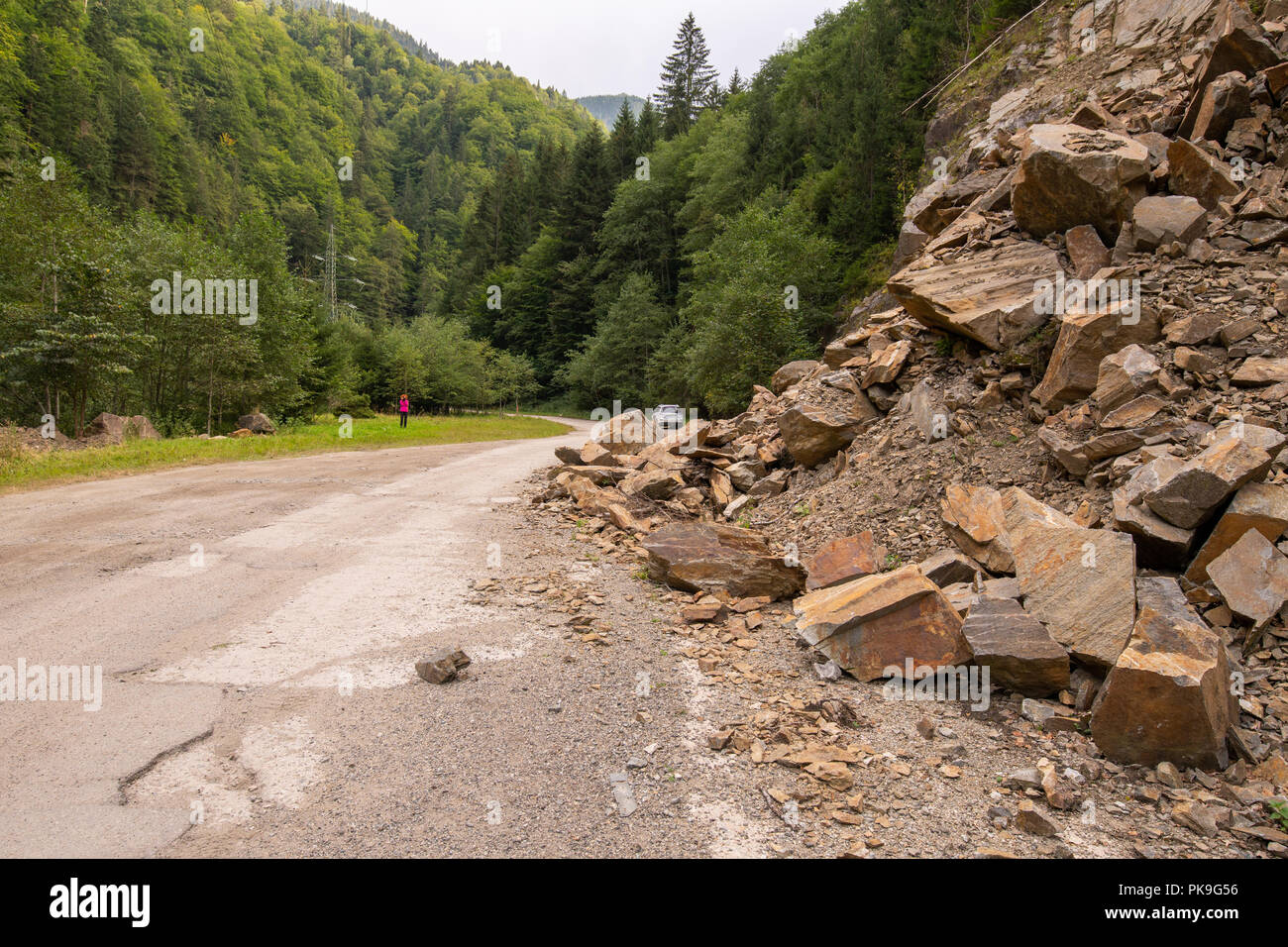 Asphalt road broken by a mountain avalanche Stock Photo - Alamy