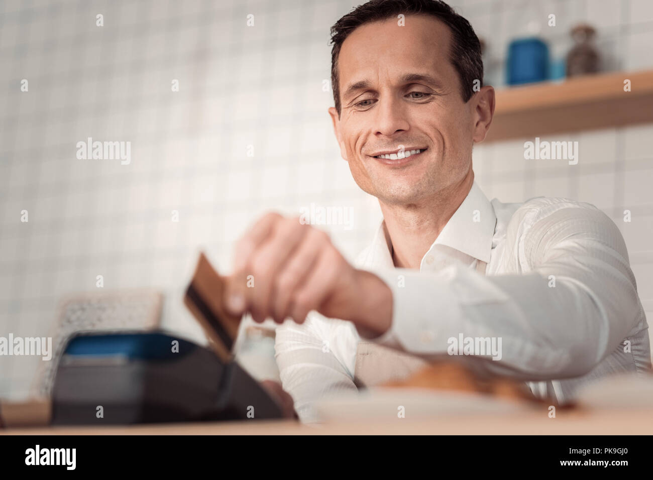 Nice positive man using the terminal Stock Photo - Alamy