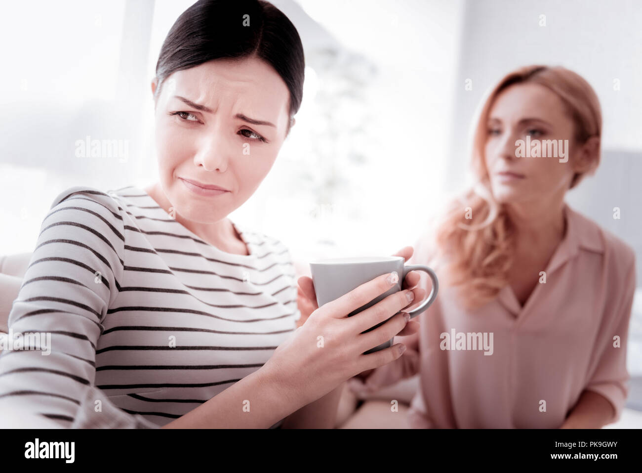 Unhappy woman turning her head while crying and drinking tea Stock ...