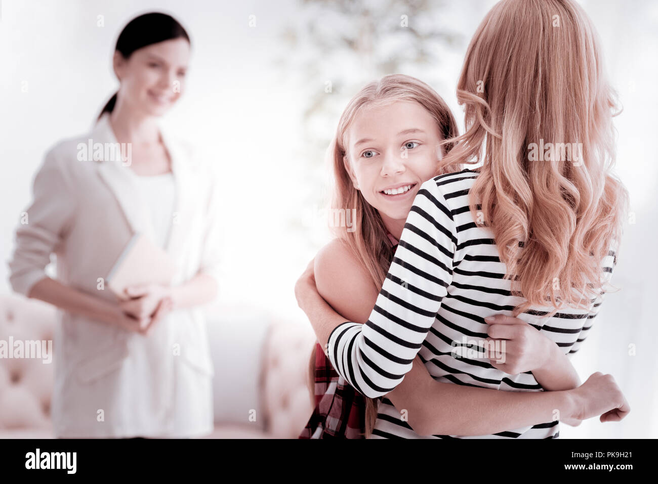 Cheerful girl smiling and hugging her kind loving mother Stock Photo ...