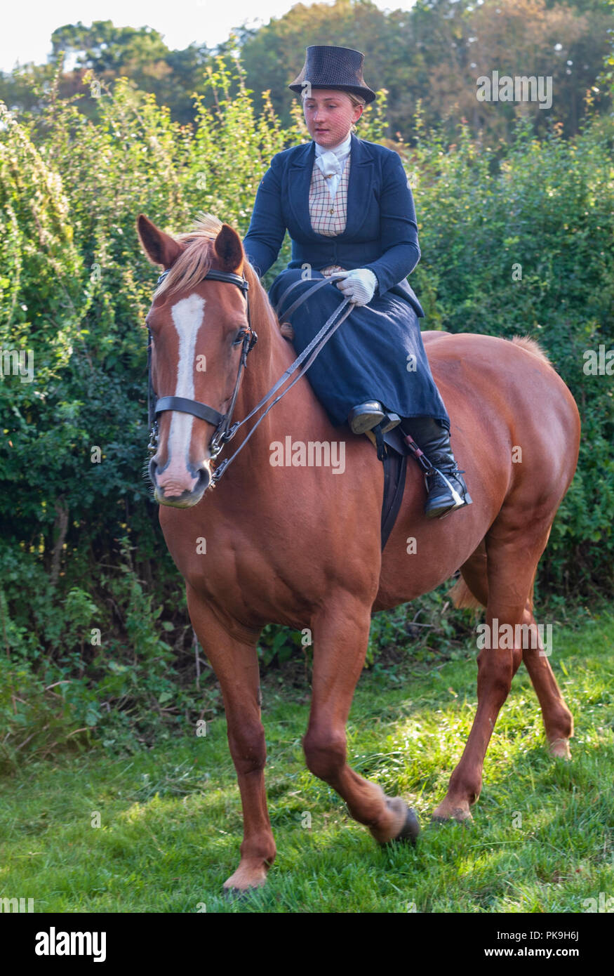 An elegent young lady riding in a traditional side saddle wearing top ...