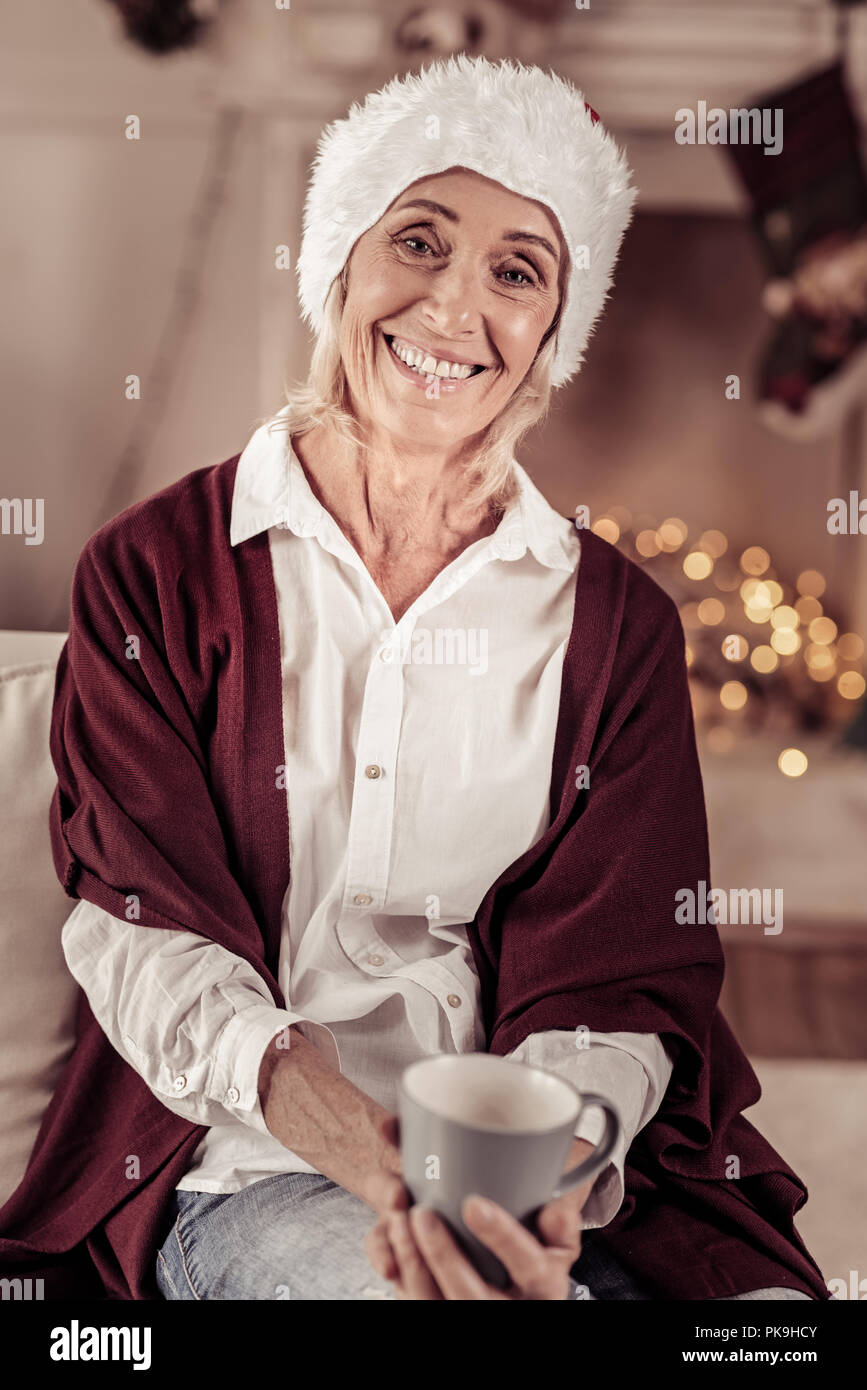Joyful pleasant woman sitting and smiling Stock Photo - Alamy