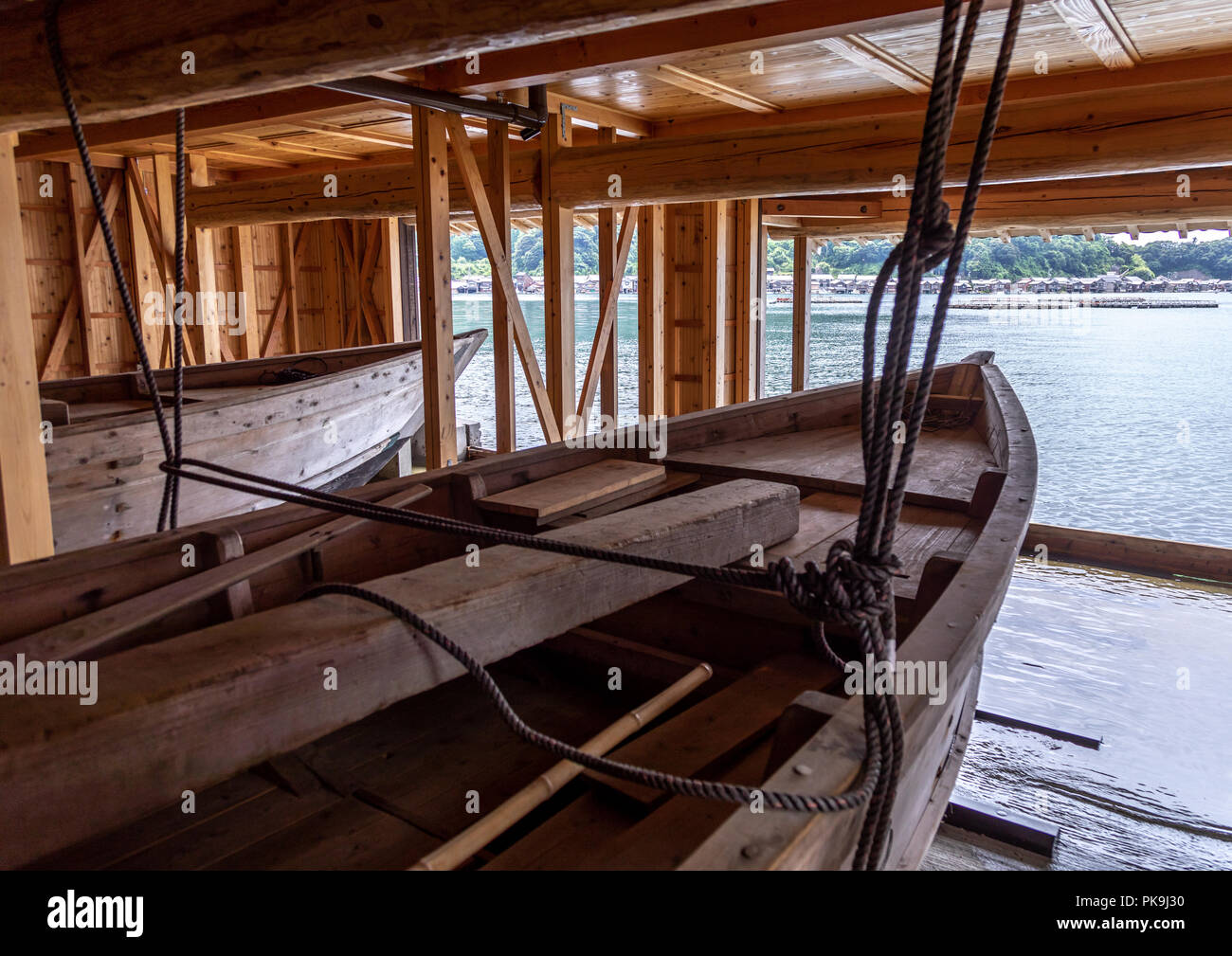 Traditional wooden boats parked inside a funaya house, Kyoto prefecture ...
