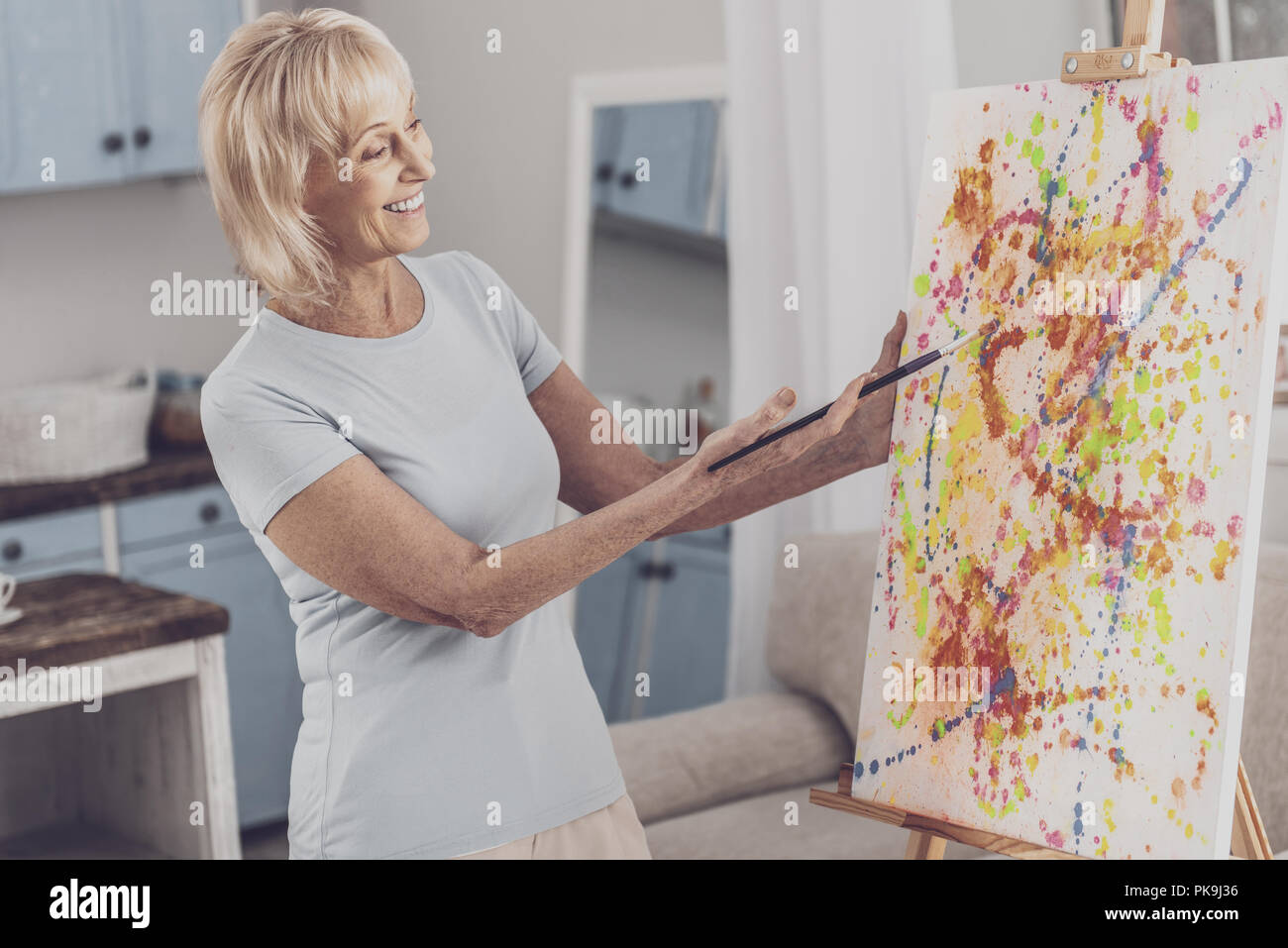 Pleasant looking woman in white shirt feeling joyful Stock Photo - Alamy