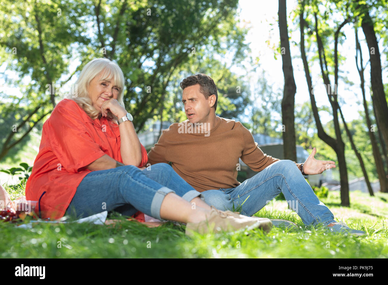 Negative delighted man looking at his sad mom Stock Photo - Alamy
