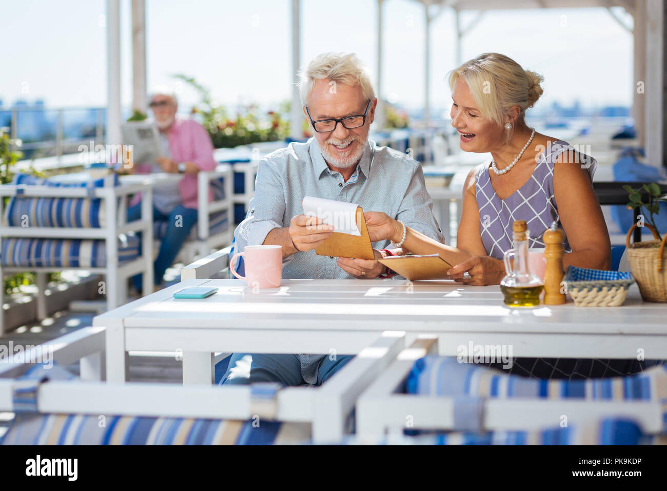 Happy cheerful man pointing at the menu Stock Photo - Alamy