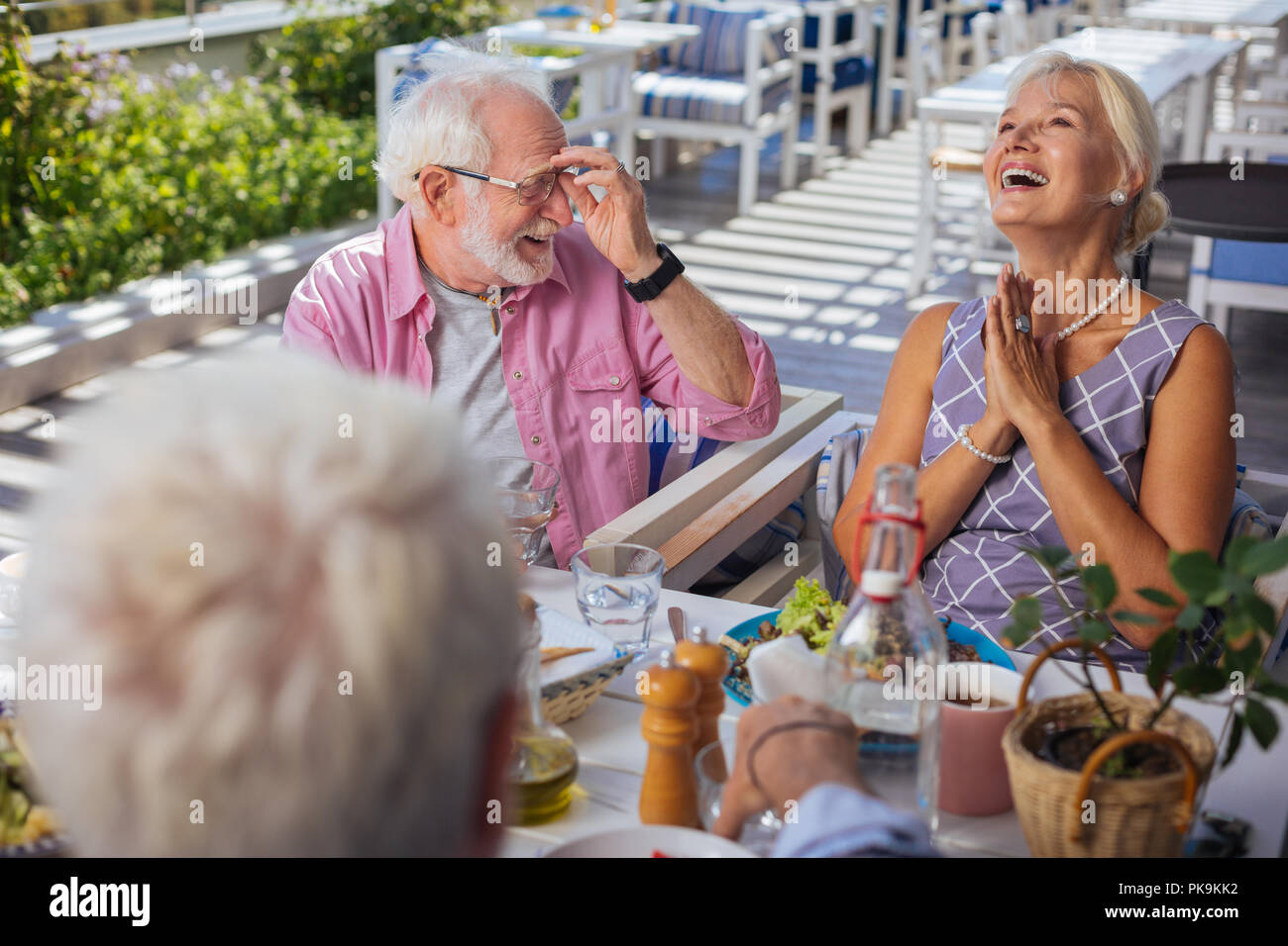 Delighted nice people telling each other jokes Stock Photo - Alamy