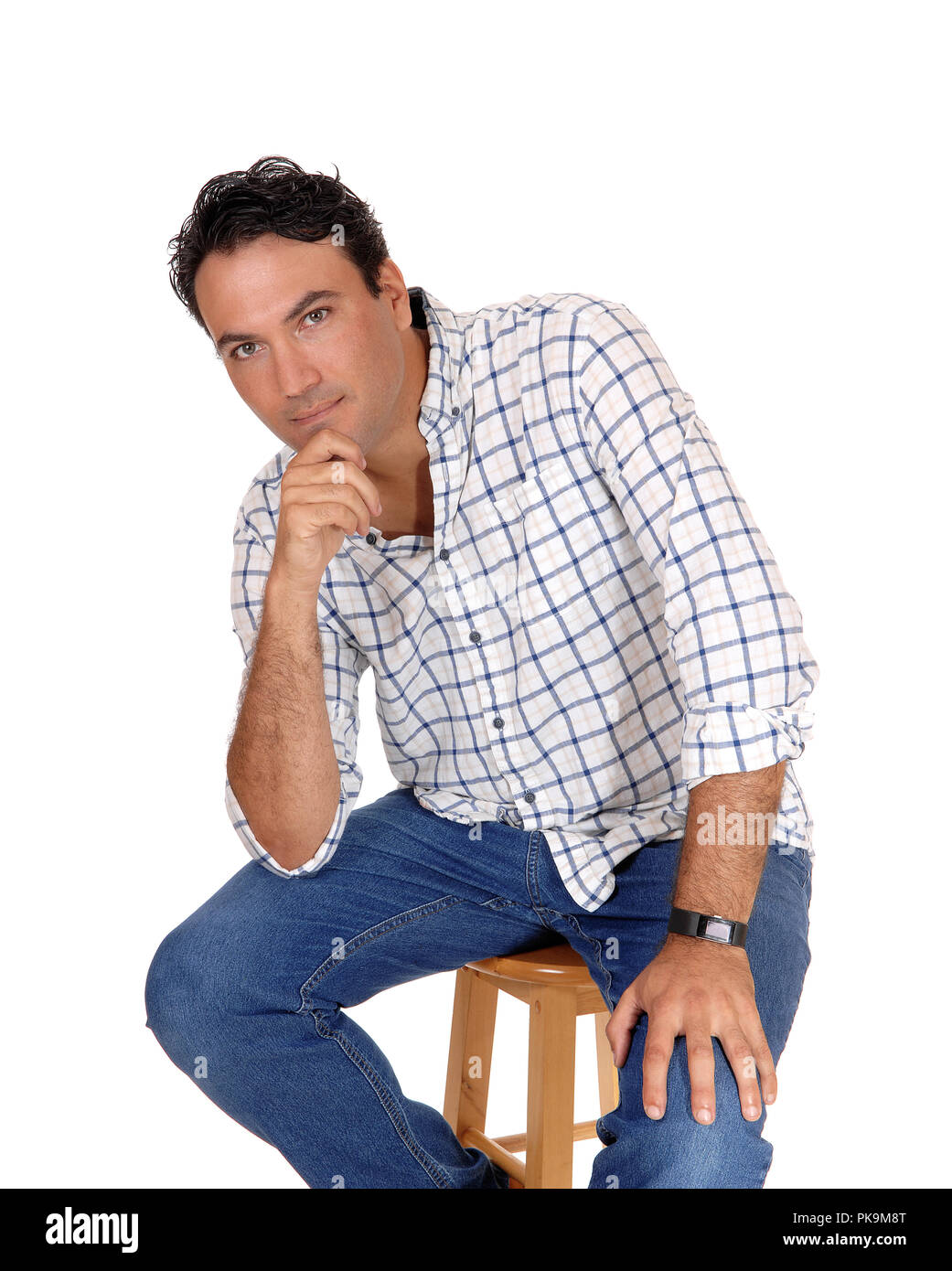 A portrait image of a tall handsome young man sitting on a chair with ...