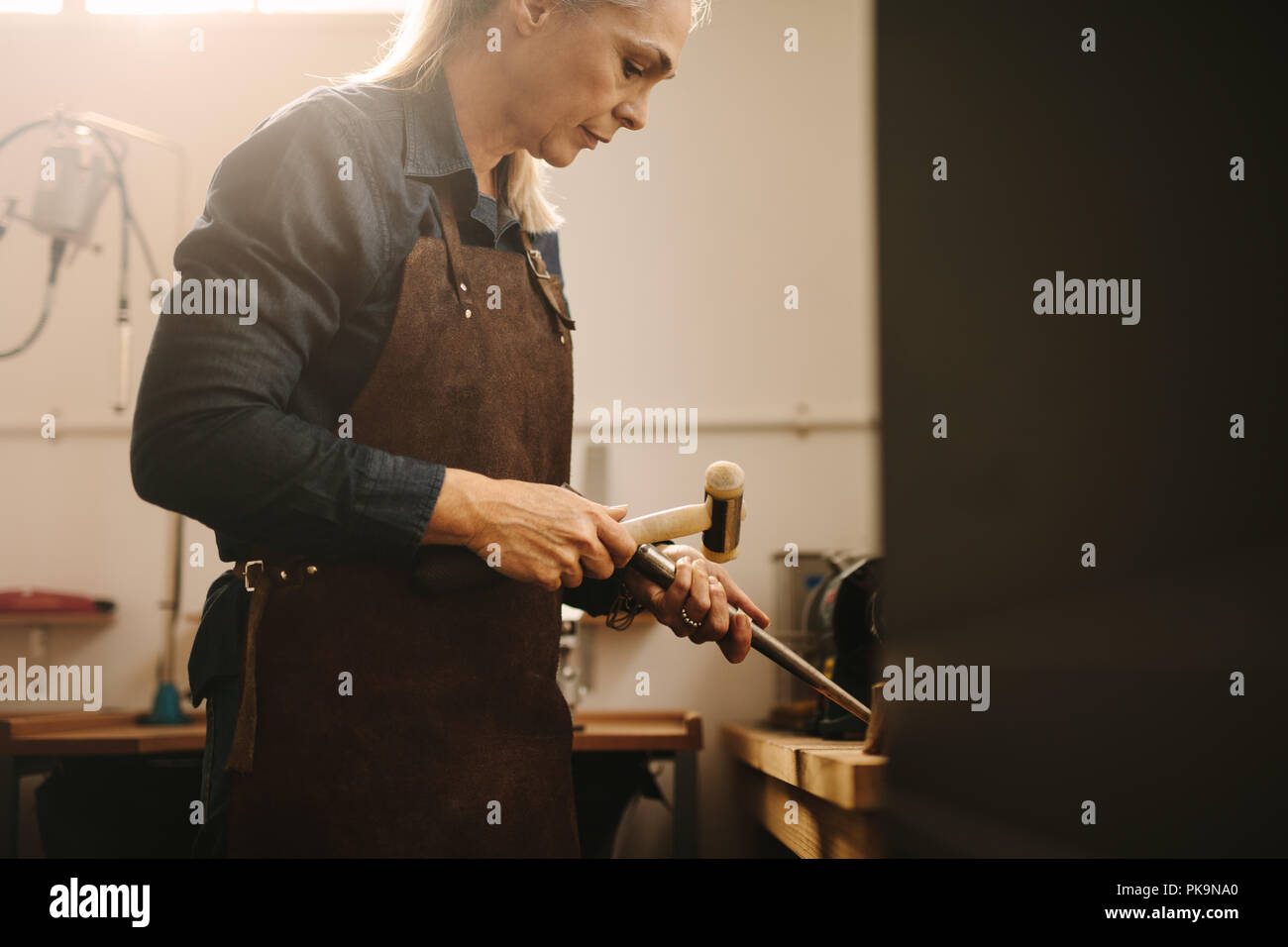 Professional female jeweler making jewelry using traditional tools in ...