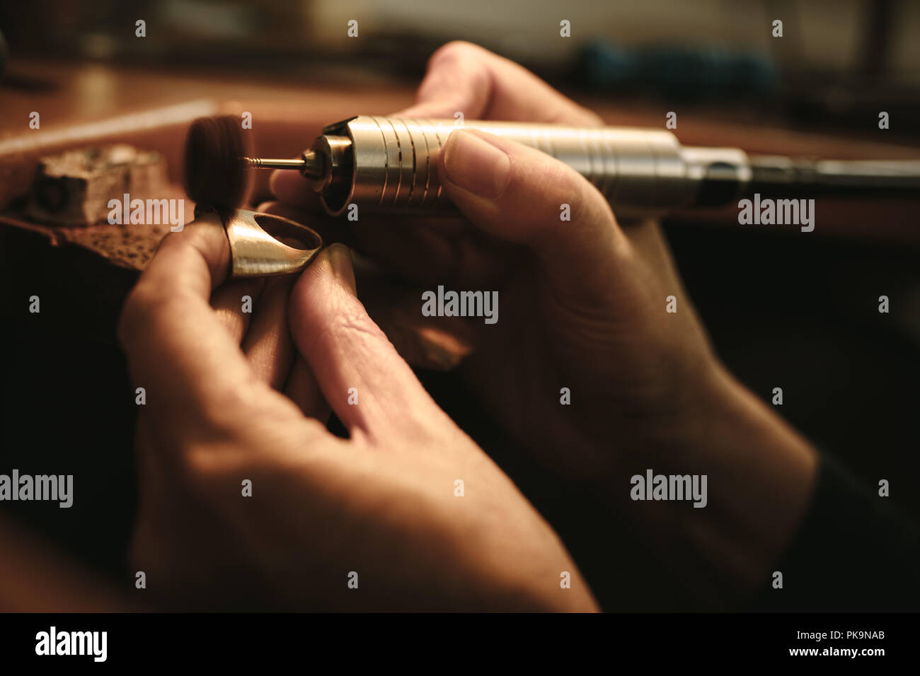 Hands of woman jeweler polishing a ring surface with grinding machine ...