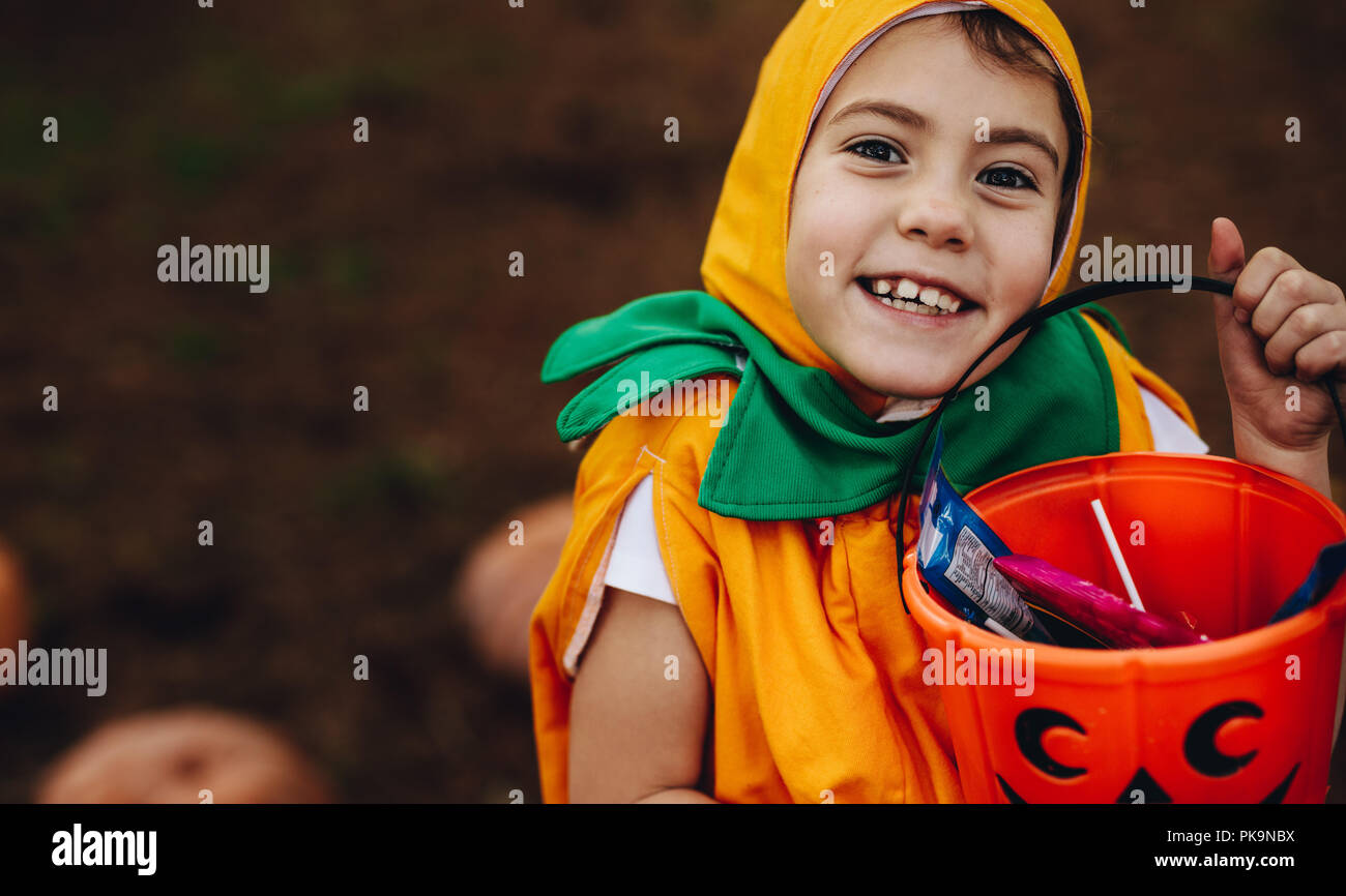 Close up portrait of cute little girl in Halloween costume holding ...