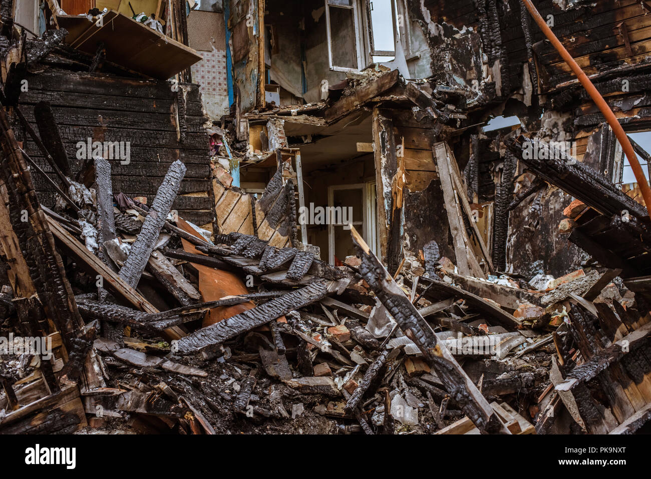 the old wooden burned-down house with furniture a view from inside ...
