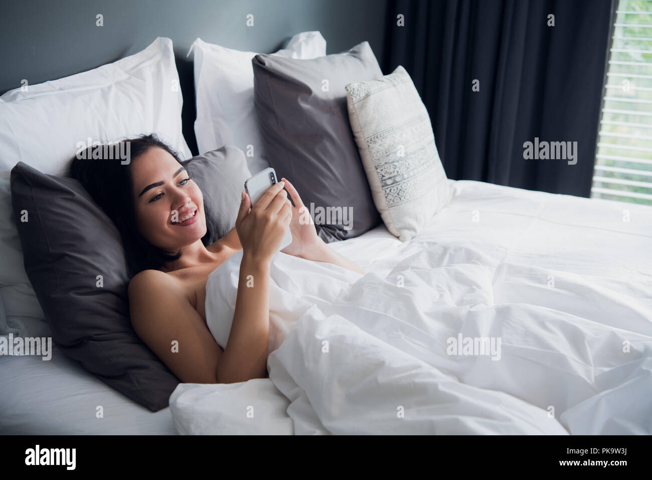 Happy attractive young European female smiling broadly while reading ...