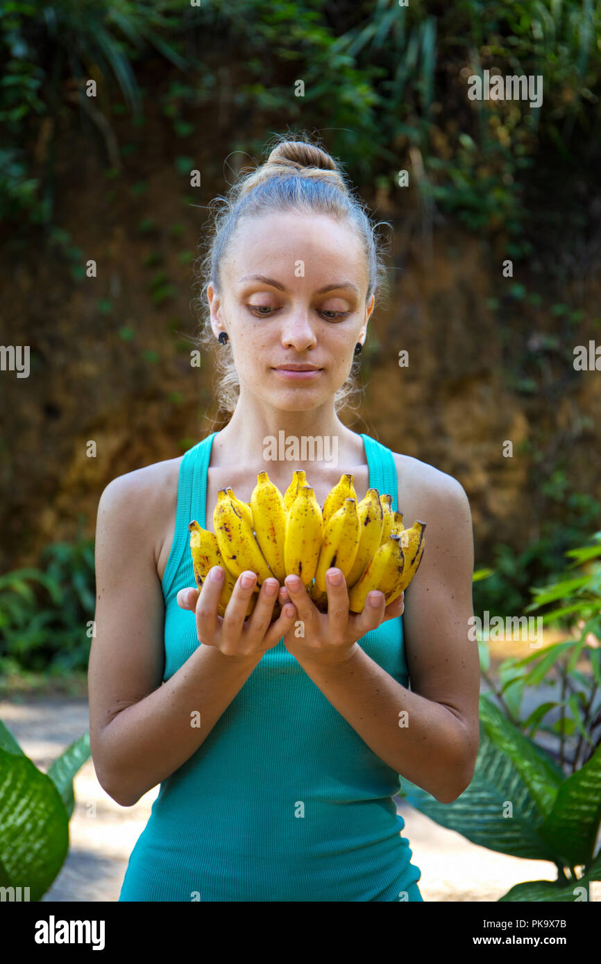 girl with mini bananas on tropical garden background Stock Photo - Alamy