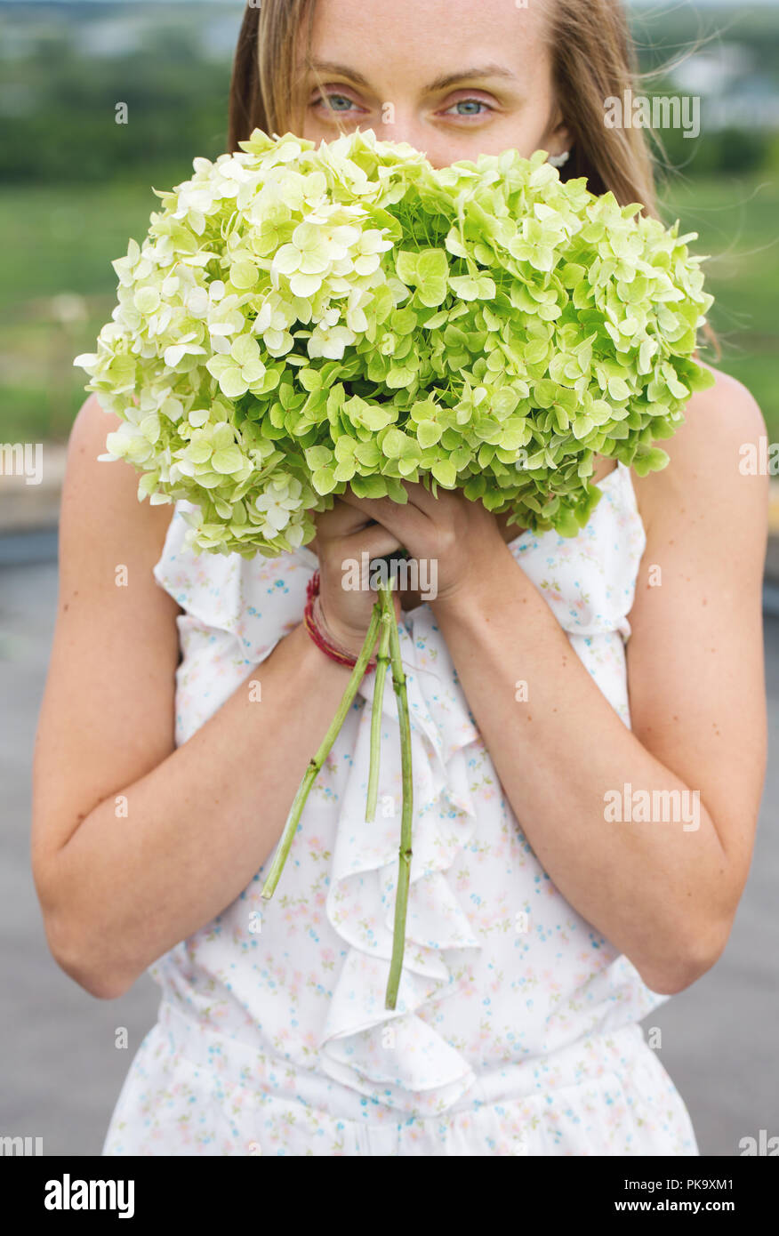 young woman sniffing a bouquet of a hydrangea Stock Photo - Alamy