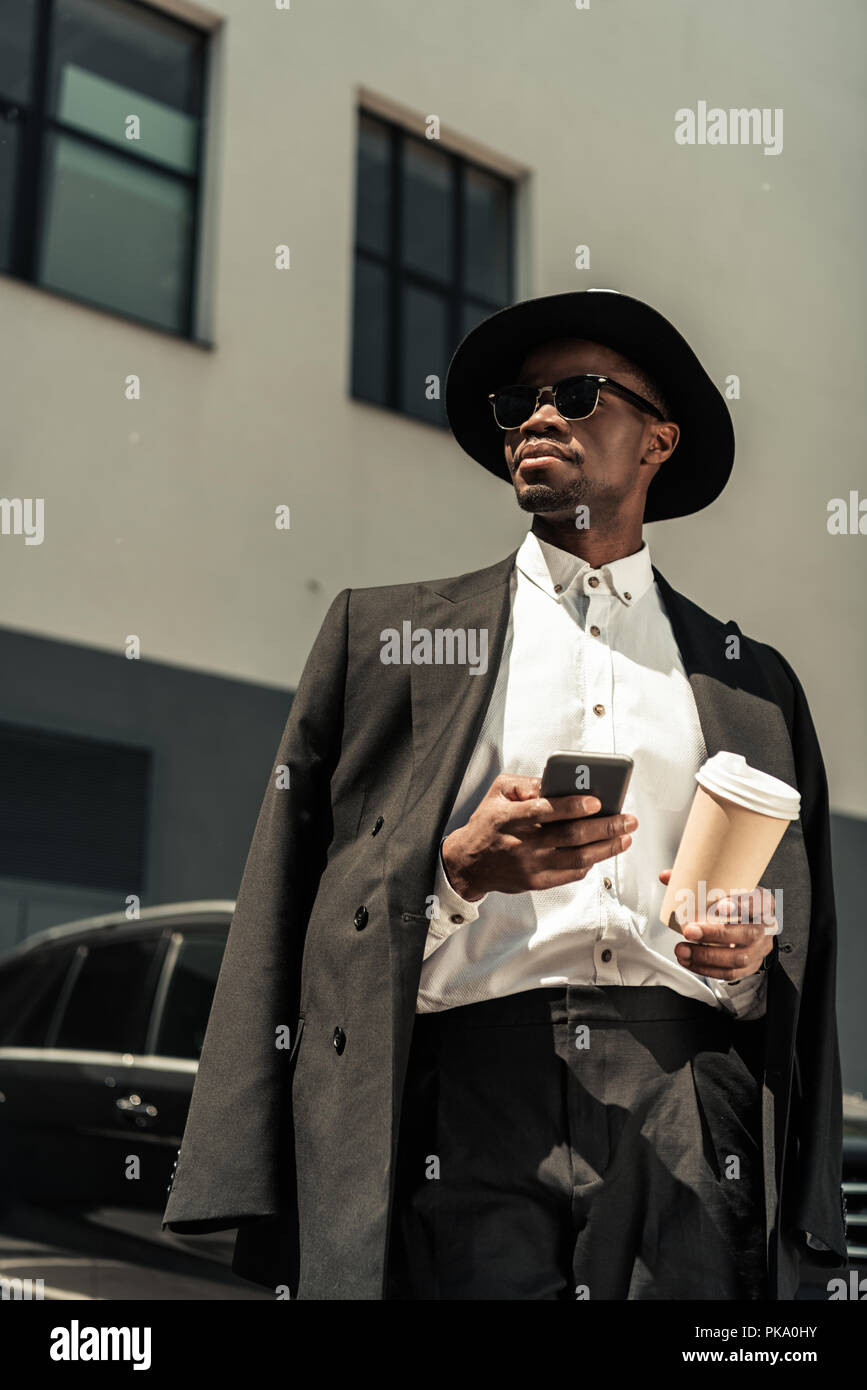 Fashionable african american businessman wearing fedora hat using ...