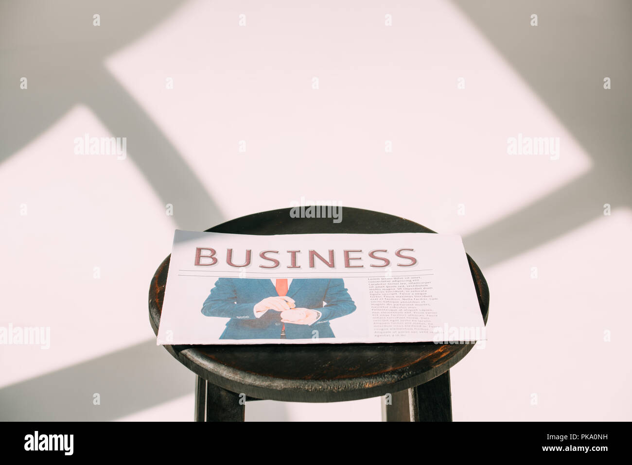 close-up view of business newspaper on wooden stool on white Stock ...