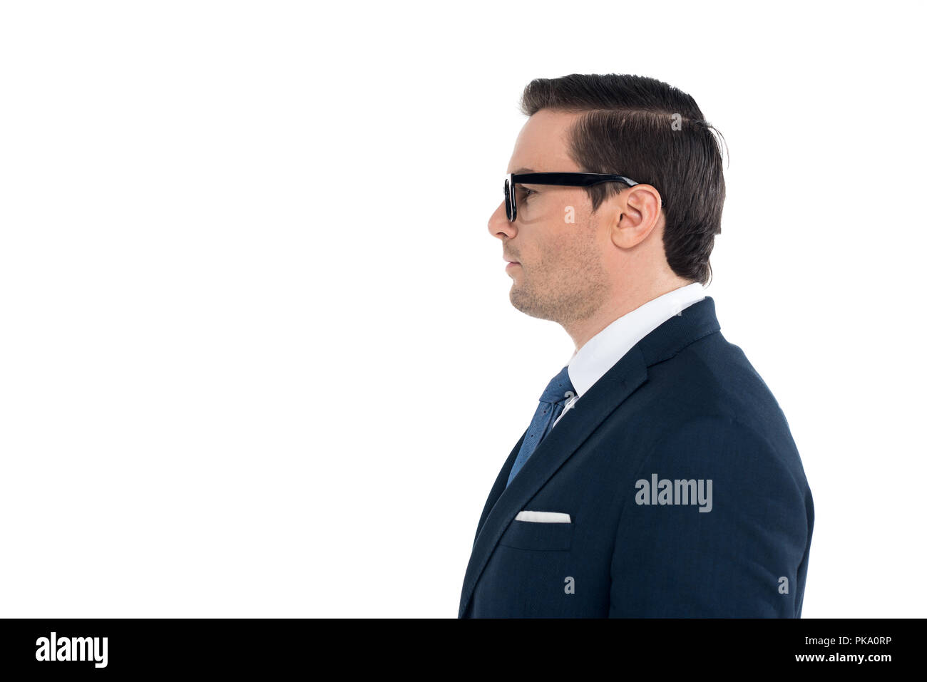 side view of businessman in suit and eyeglasses standing and looking ...