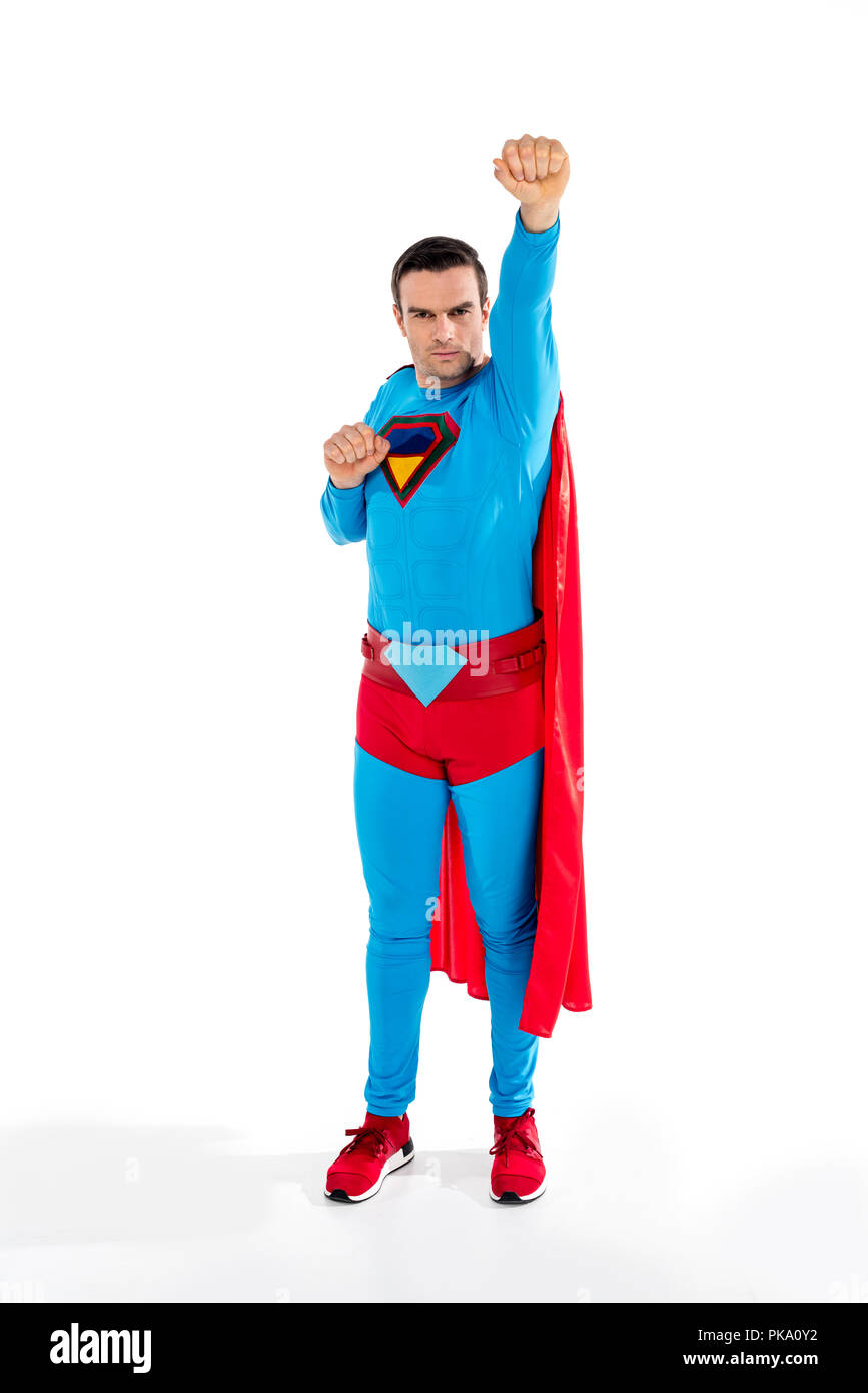 full length view of handsome male superhero raising hand and looking at ...