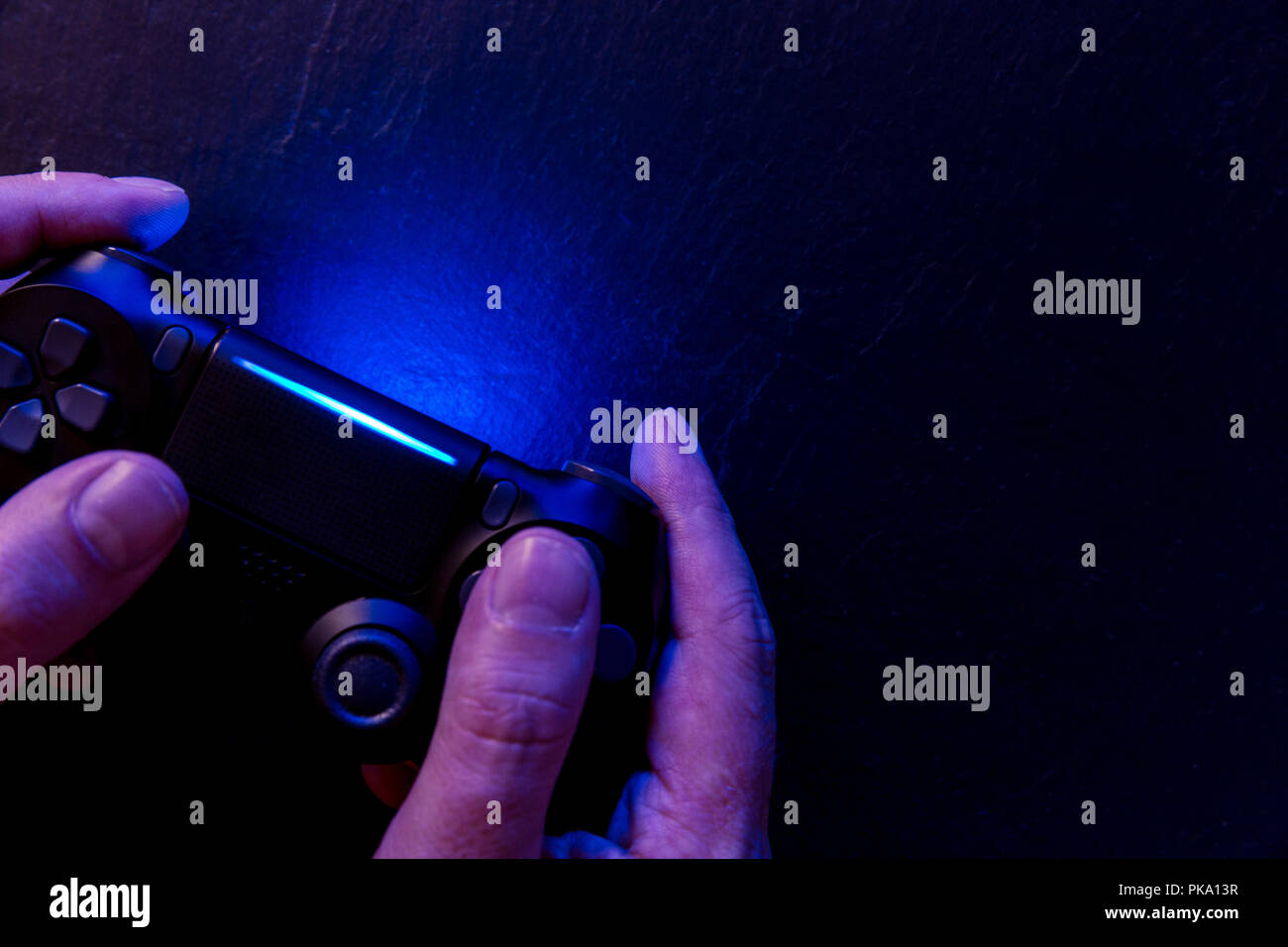 Man playing video game with controller at night with lights Stock Photo ...