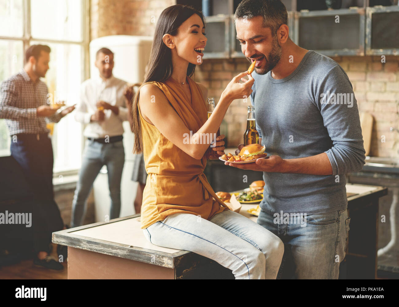 Beautiful young couple is feeding each other and smiling Stock Photo ...