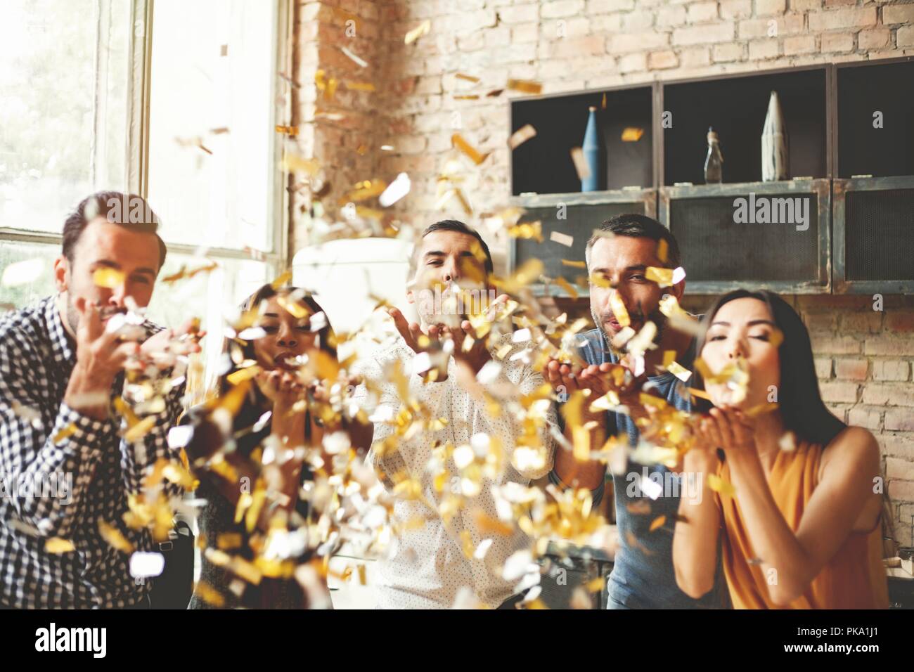 Party fun. Group of beautiful young people throwing colorful confetti ...