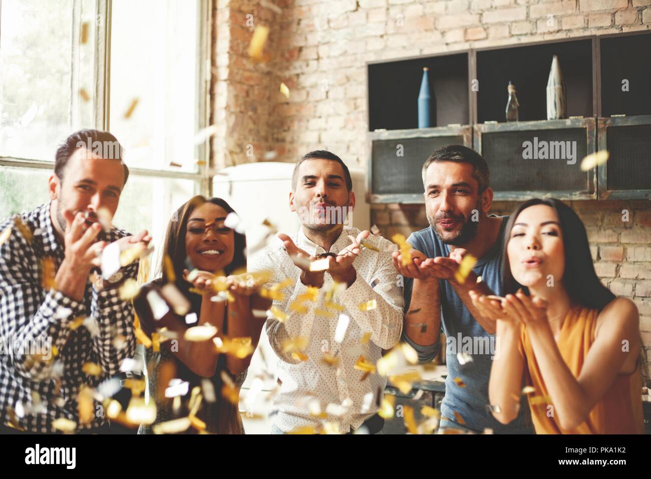 Party fun. Group of beautiful young people throwing colorful confetti ...