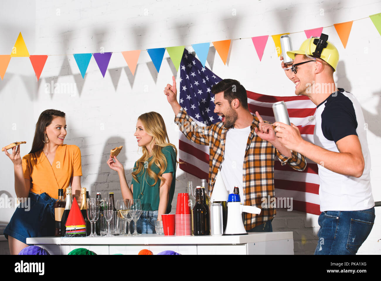 happy young friends eating snacks and drinking alcohol while having fun ...