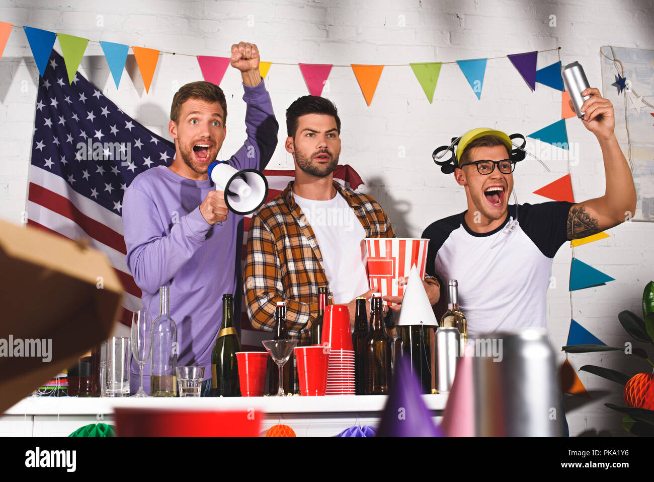 excited young men screaming and having fun while partying at home Stock ...