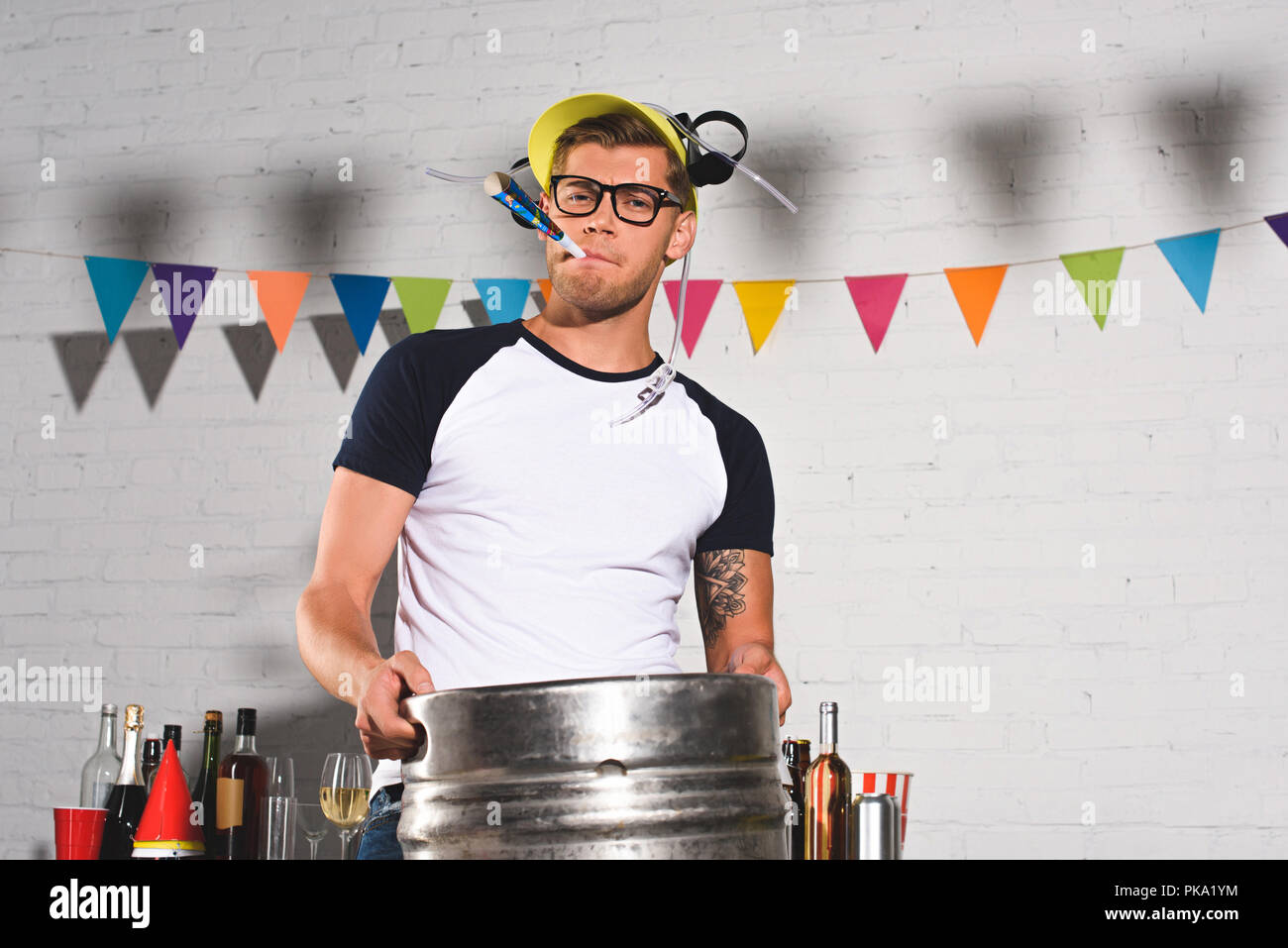 handsome young man in beer hat holding keg of beer and smiling at ...