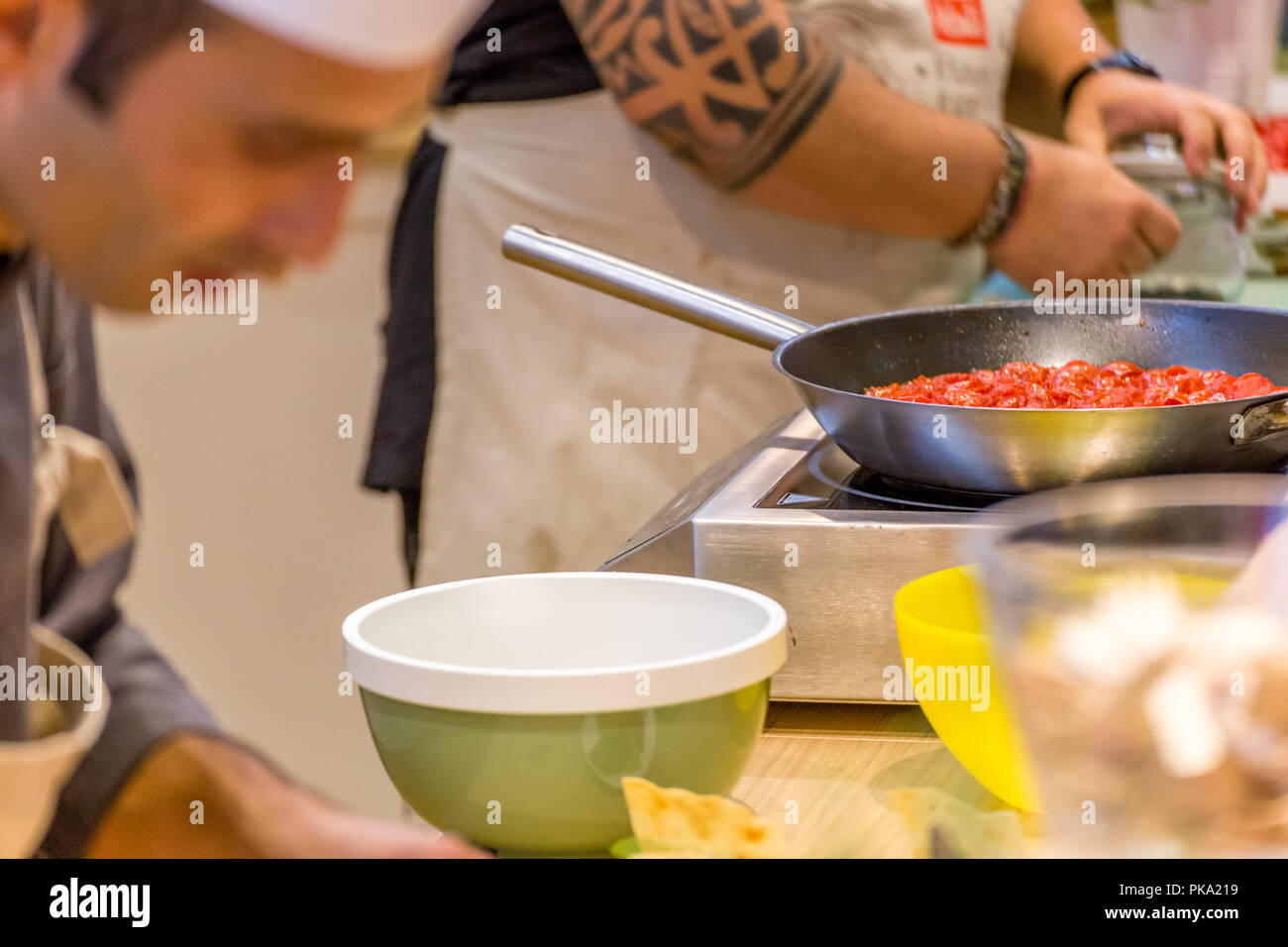 BOLOGNA (ITALY), SEPTEMBER 10, 2018: booth presenter is cooking food ...