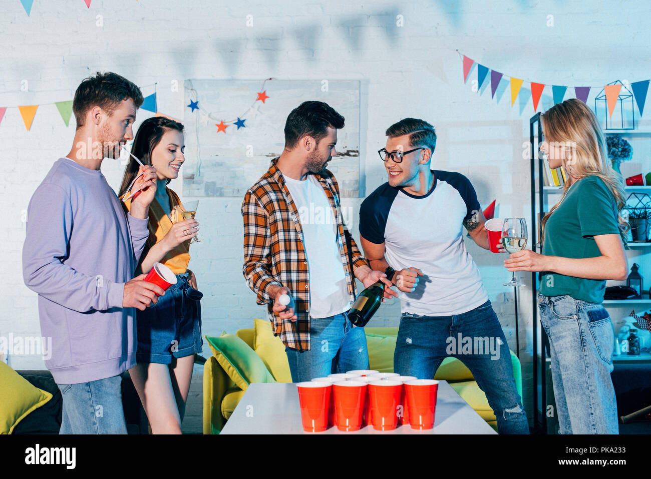 happy young friends drinking alcoholic beverages and partying together ...